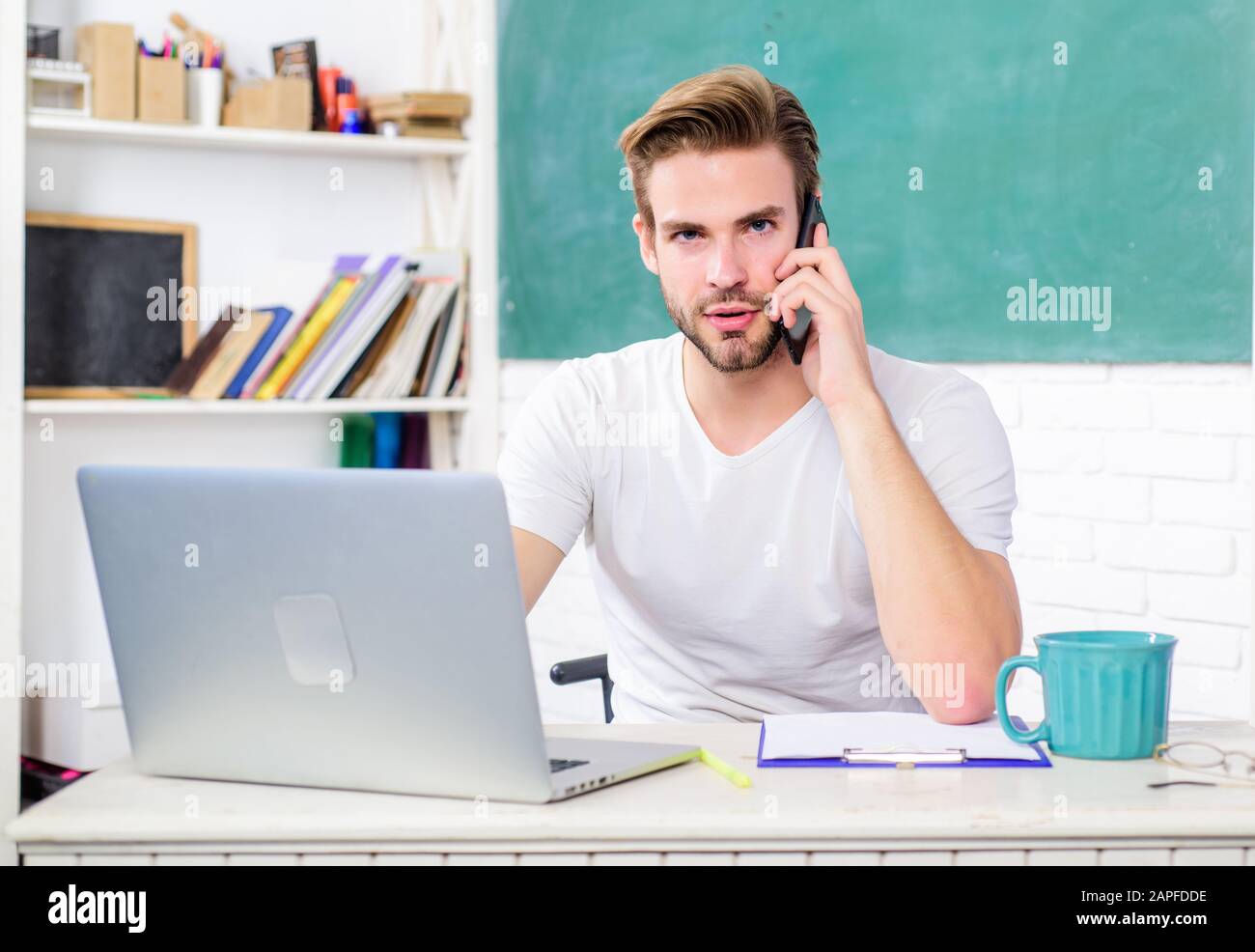 job interview. student man in classroom with tea cup. man make note and ...