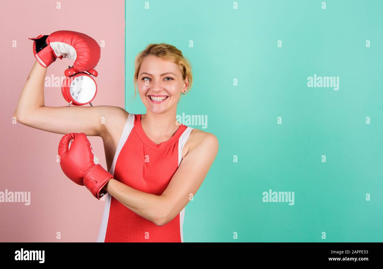 Punctuality and personal efficiency. girl boxer hold alarm clock ...