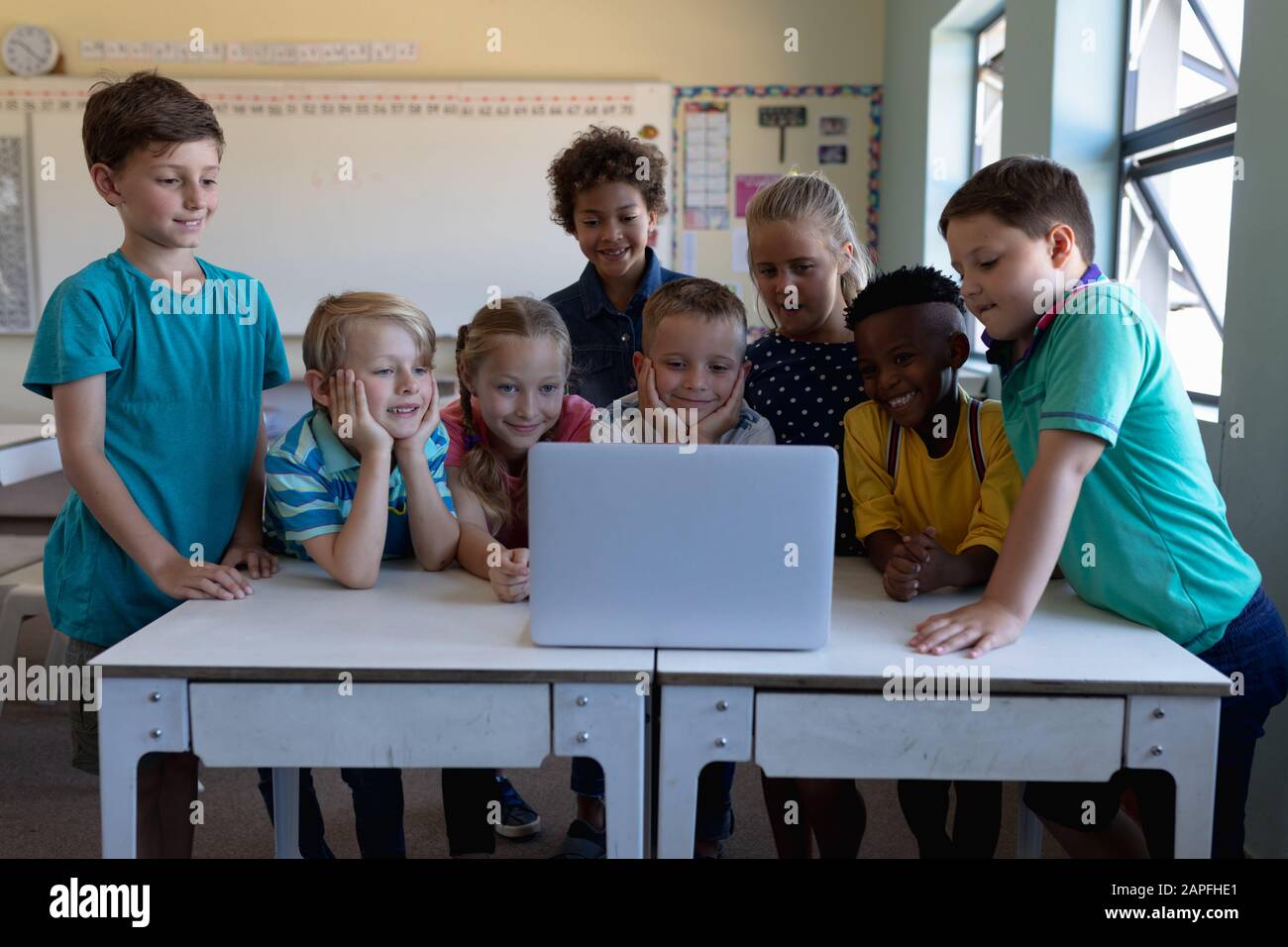 Group of schoolchildren using a laptop computer in an elementary school ...