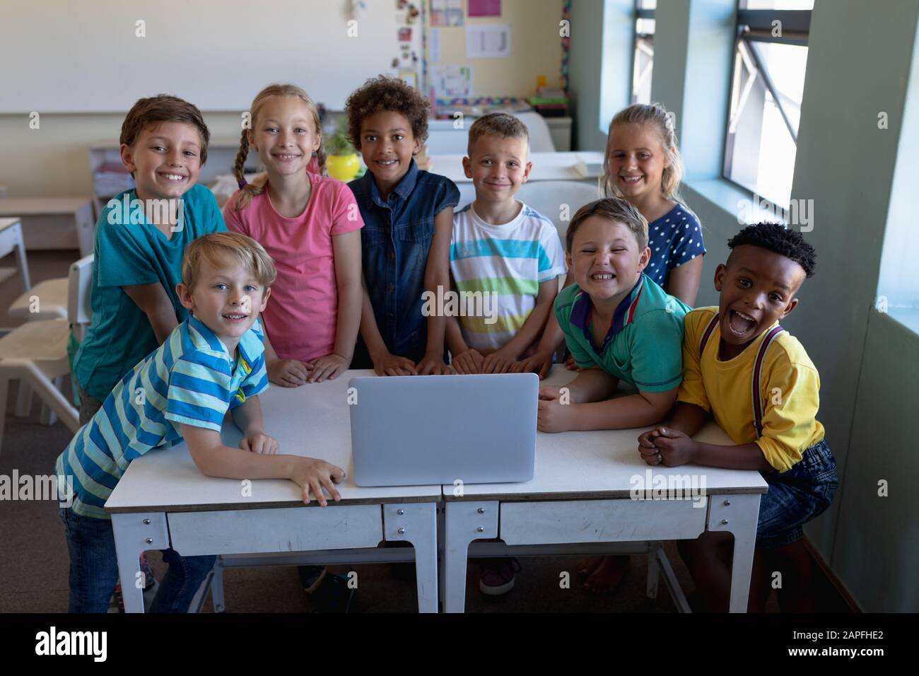 Group of schoolchildren using a laptop computer in an elementary school ...
