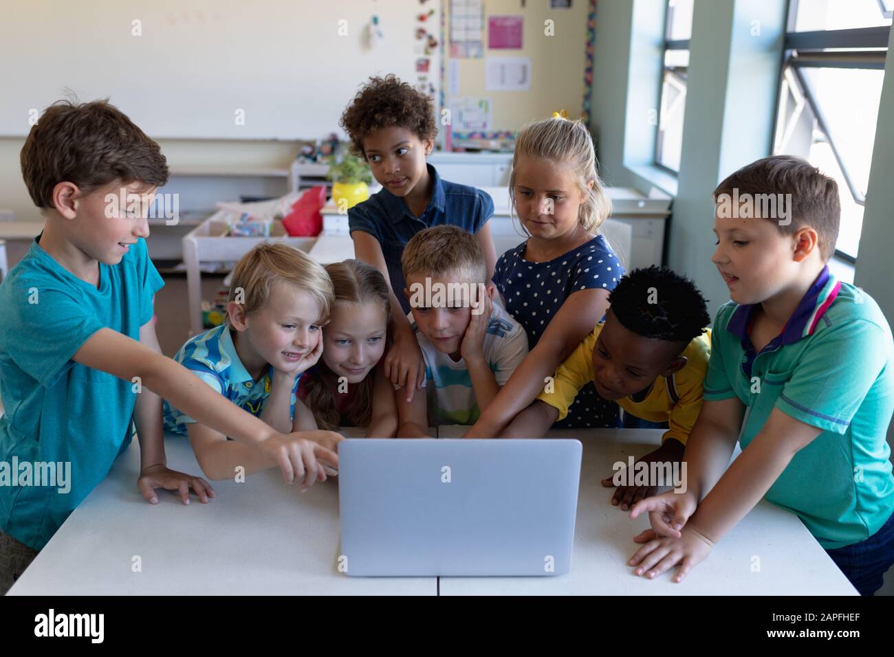Group of schoolchildren using a laptop computer in an elementary school ...