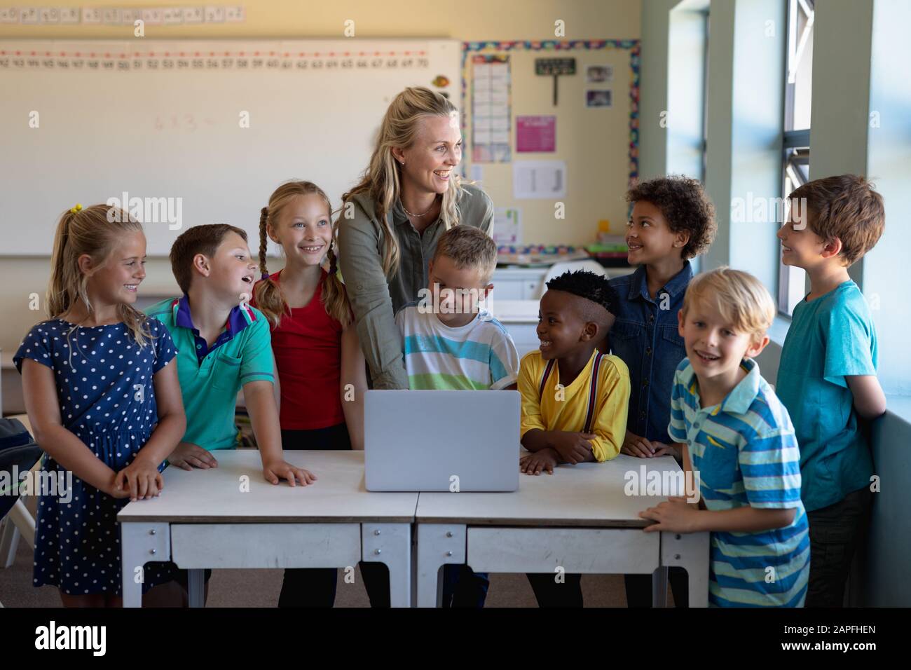 Female teacher using a laptop computer with of schoolchildren Stock ...