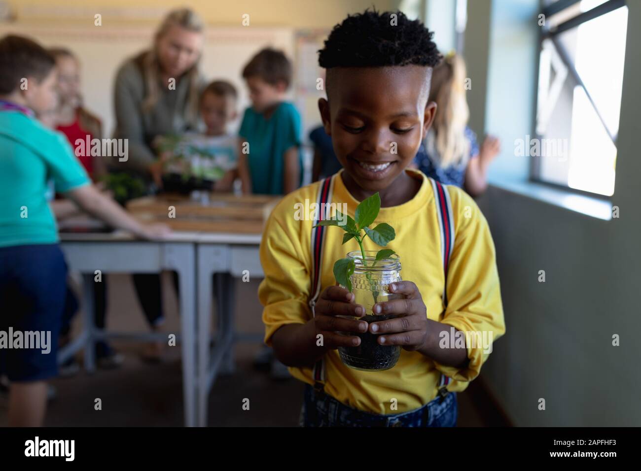 Girl holding plant in classroom hi-res stock photography and images - Alamy