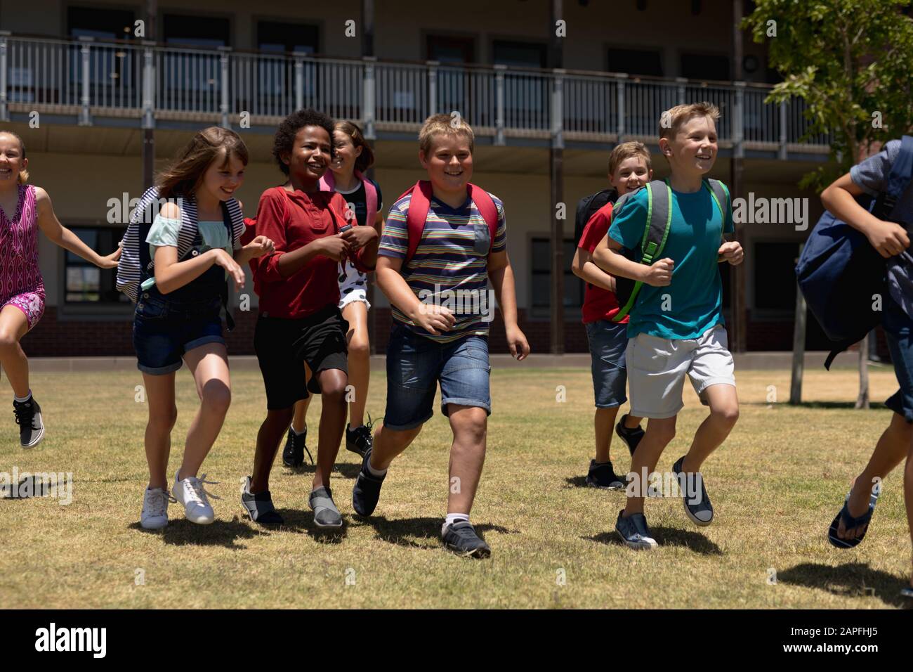 Group of schoolchildren running in a playing at elementary school Stock ...