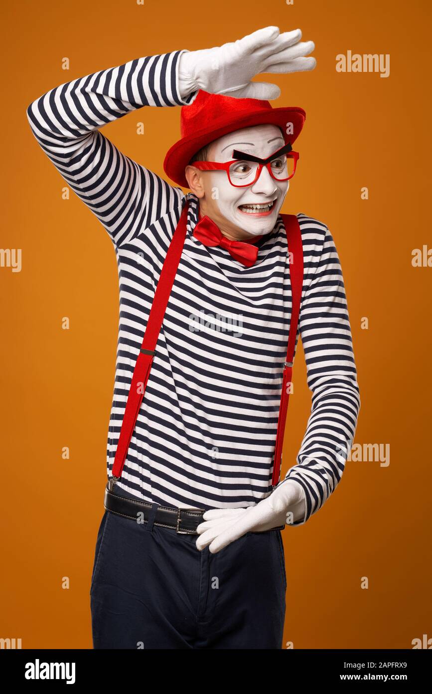Surprised mime with white face in red hat and striped t-shirt on blank ...