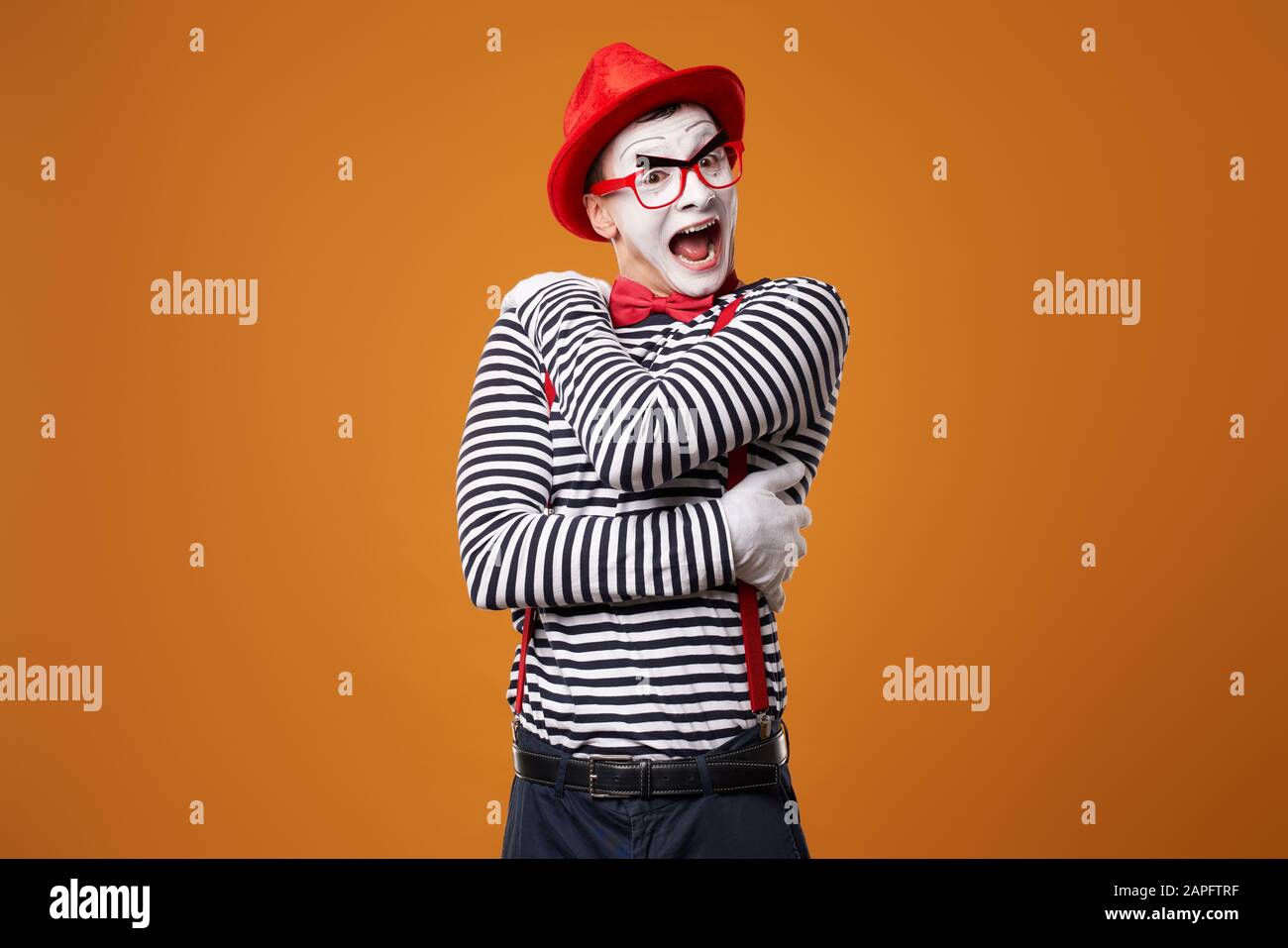 Happy mime man in vest and red hat on orange empty background Stock ...