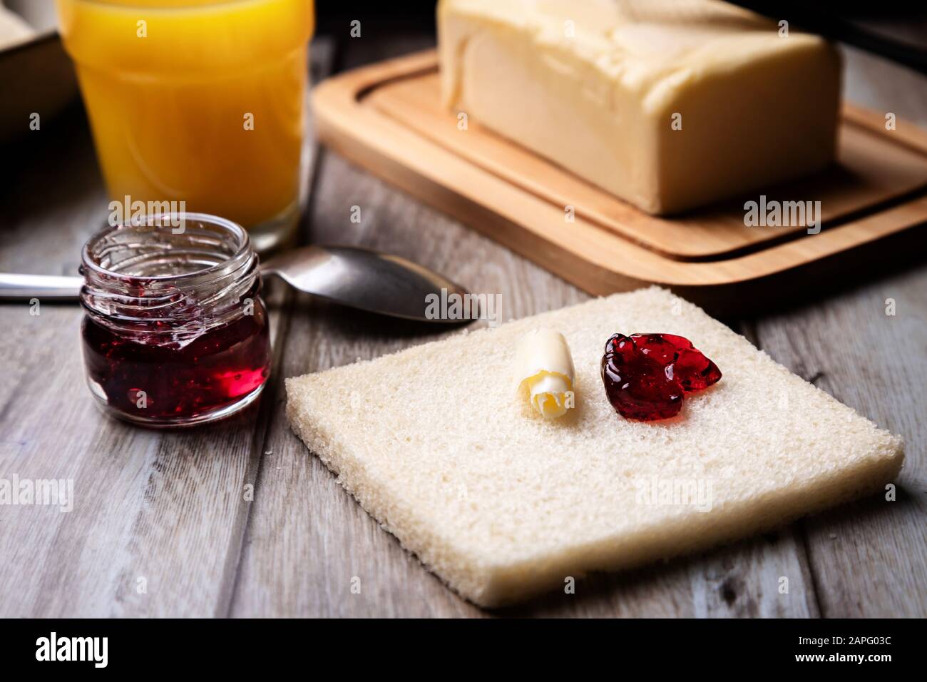 Preparation of a spread with butter and red fruit jam Stock Photo - Alamy