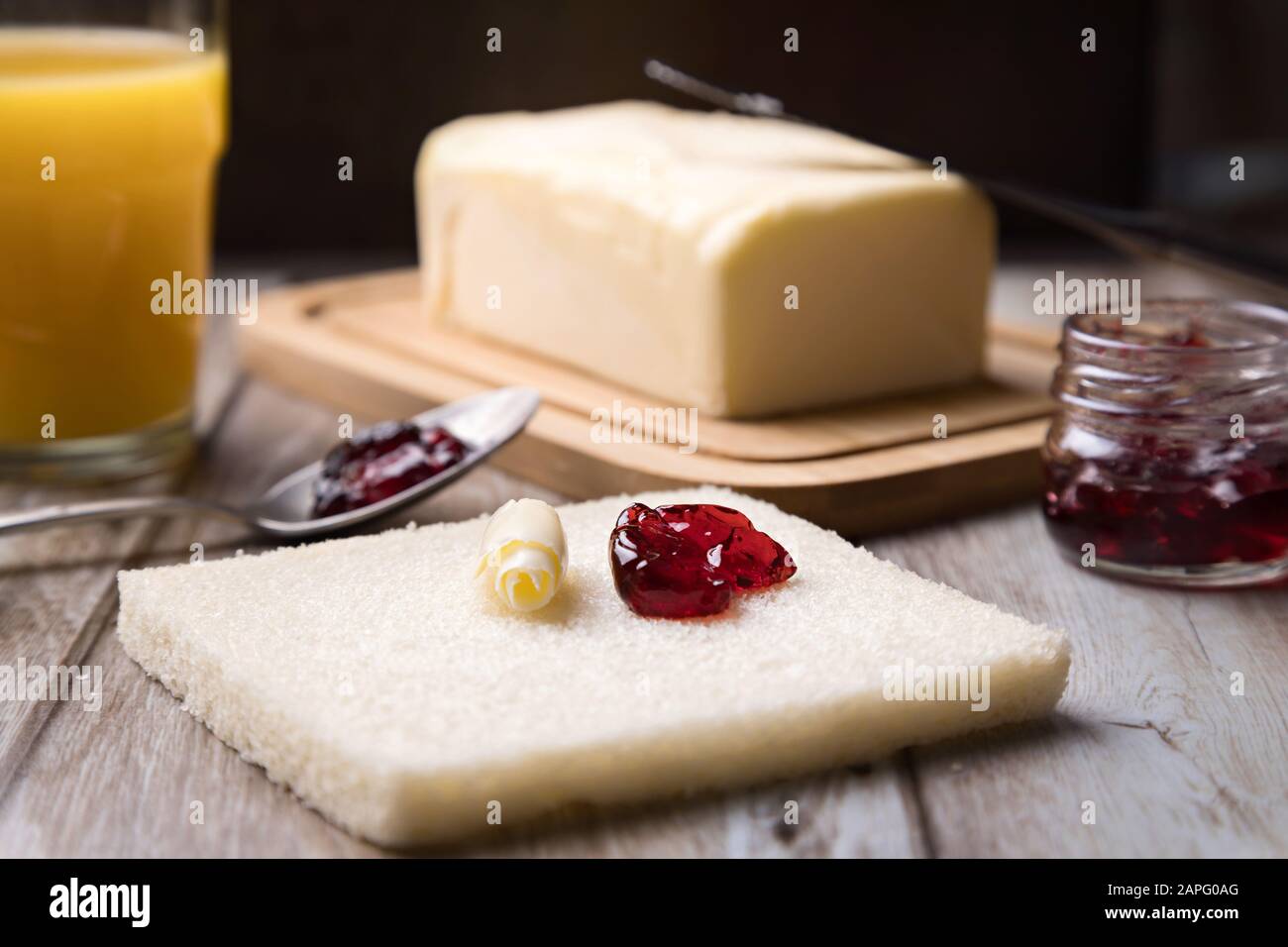 Preparation of a spread with butter and red fruit jam Stock Photo - Alamy