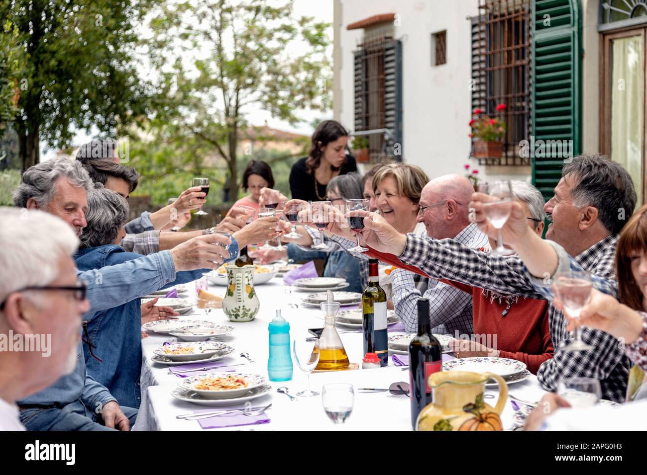 Family toasting at outdoor lunch in garden, Florence, Italy Stock Photo ...