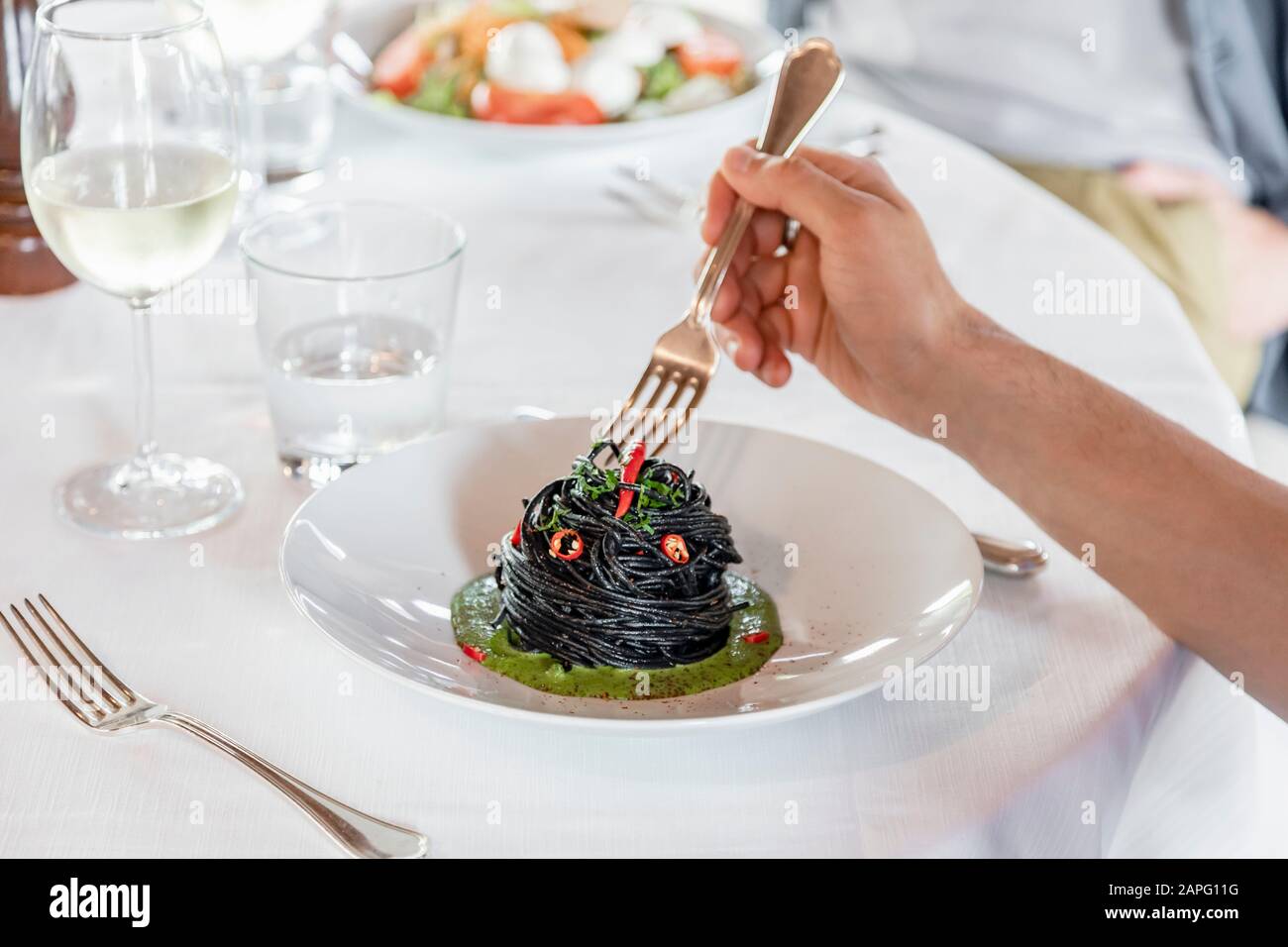 Man having squid ink pasta in restaurant Stock Photo - Alamy