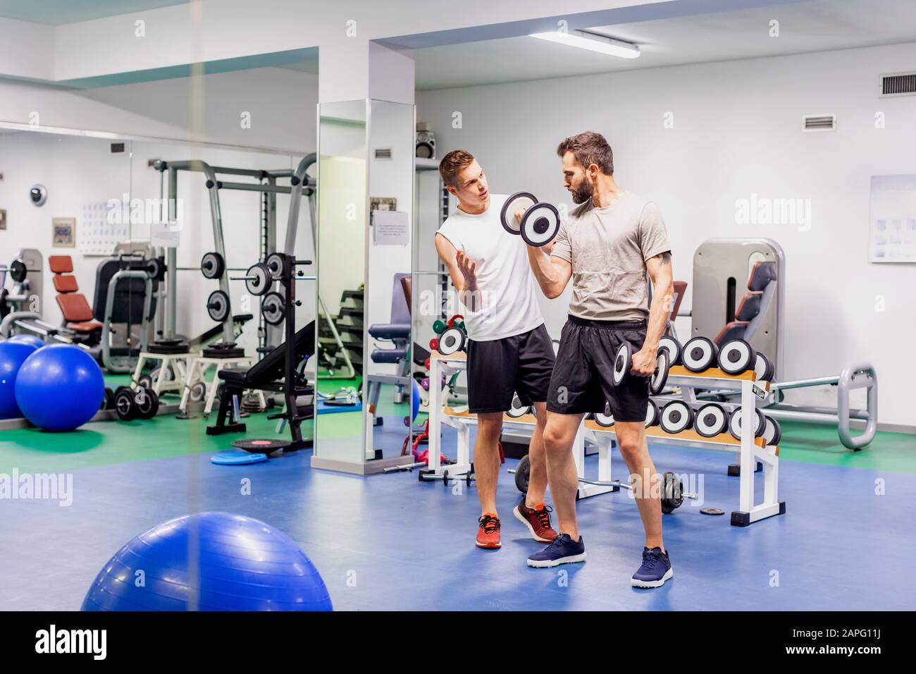 Man coaching friend in gym Stock Photo - Alamy