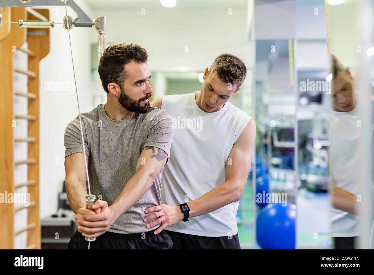 Man coaching friend in gym Stock Photo - Alamy