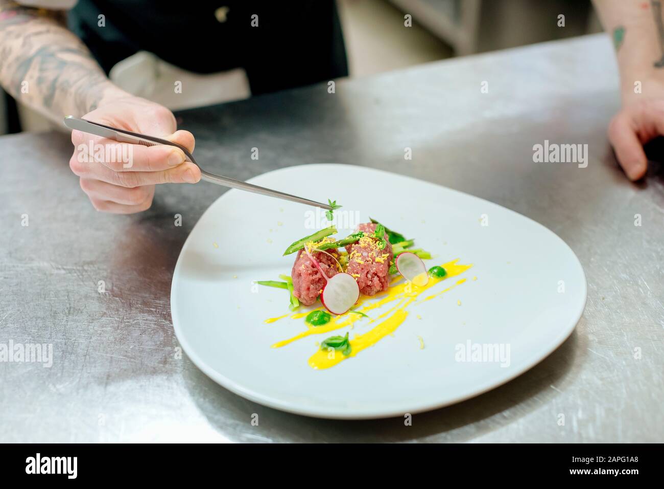 Chef preparing raw meat dish in kitchen Stock Photo - Alamy