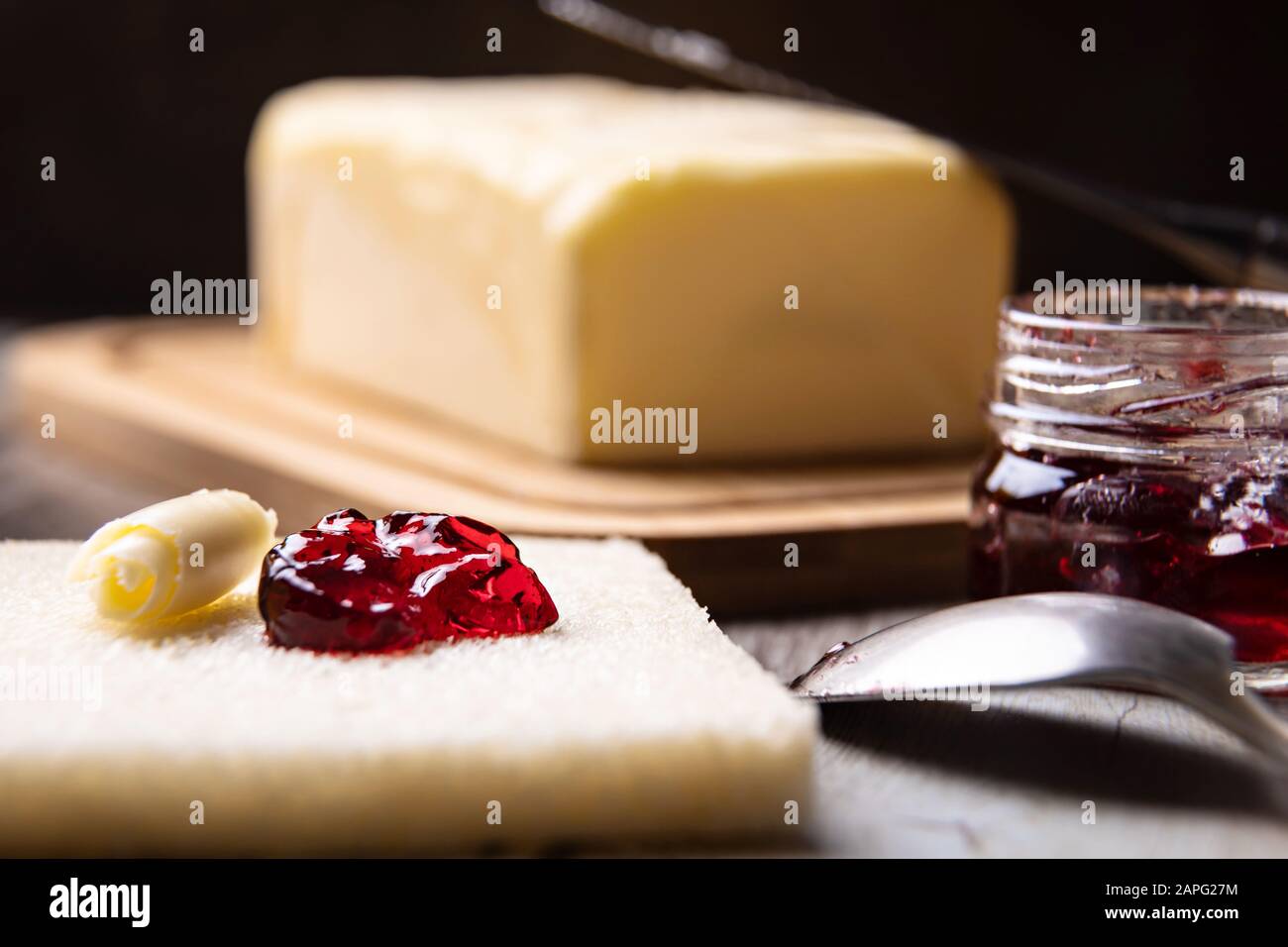 Preparation of a spread with butter and red fruit jam Stock Photo - Alamy