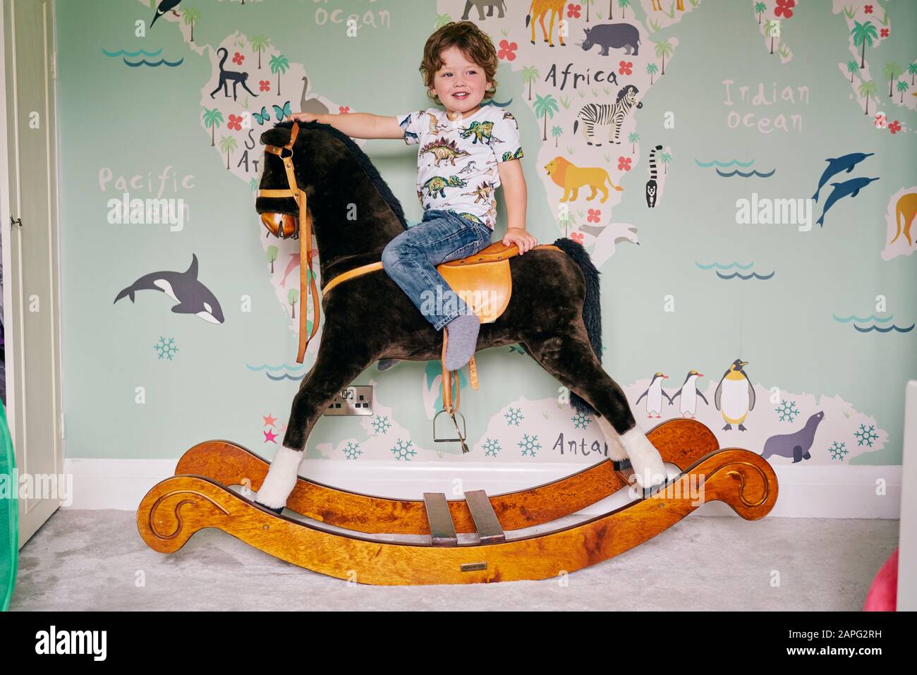Toddler riding on rocking chair in room Stock Photo - Alamy