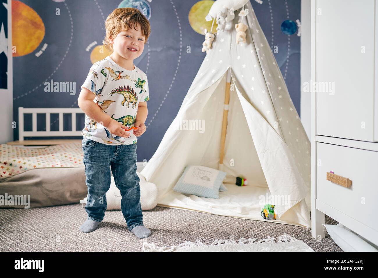 Toddler playing in room, child's teepee, mural of solar system on wall ...
