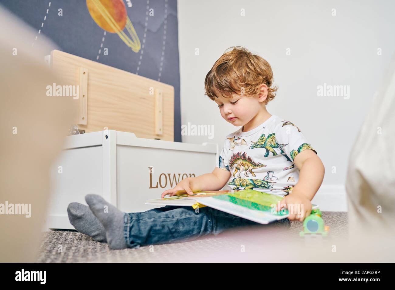 Toddler reading book in room Stock Photo - Alamy