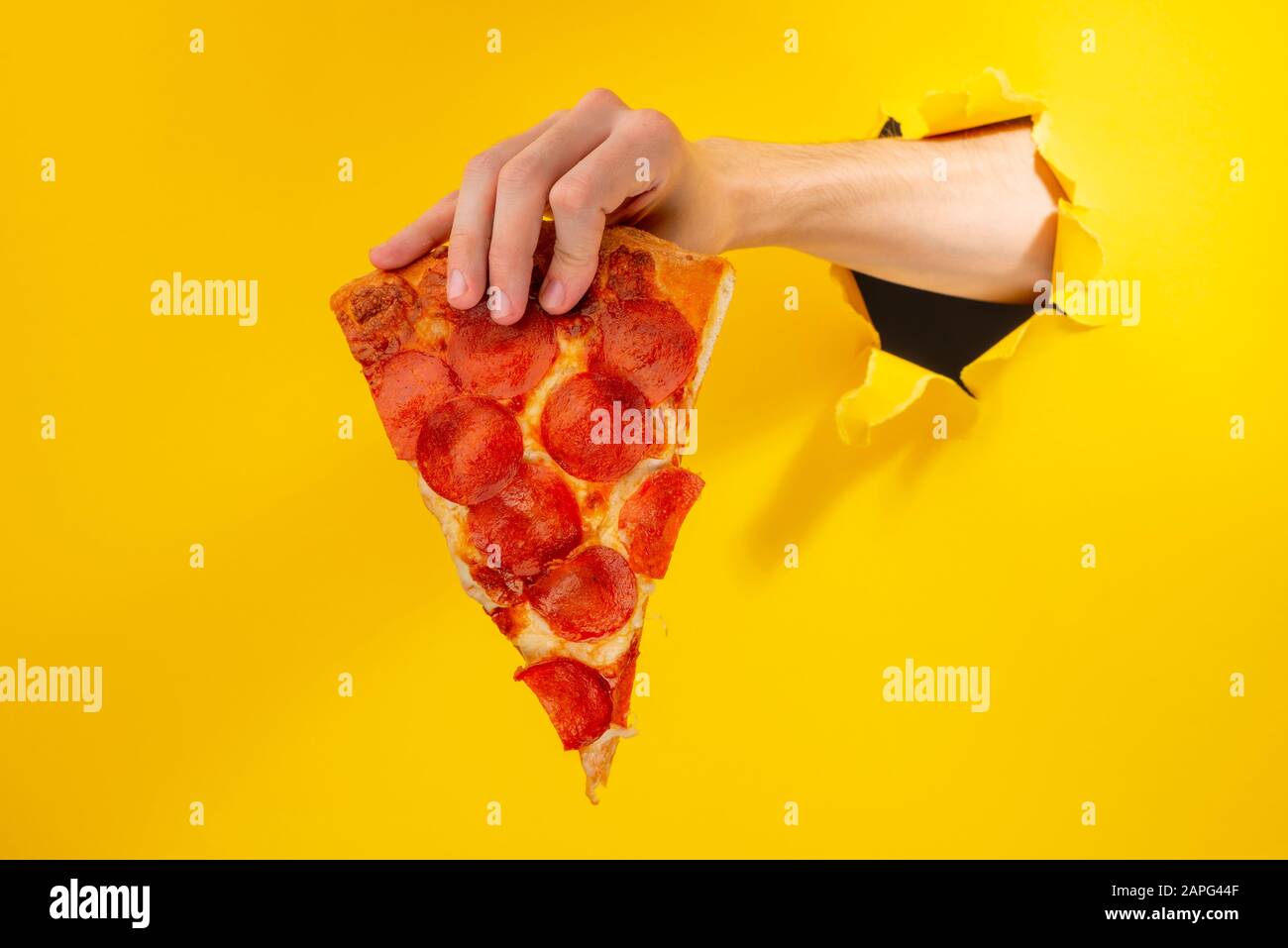 Hand giving a slice of Pepperoni pizza Stock Photo - Alamy
