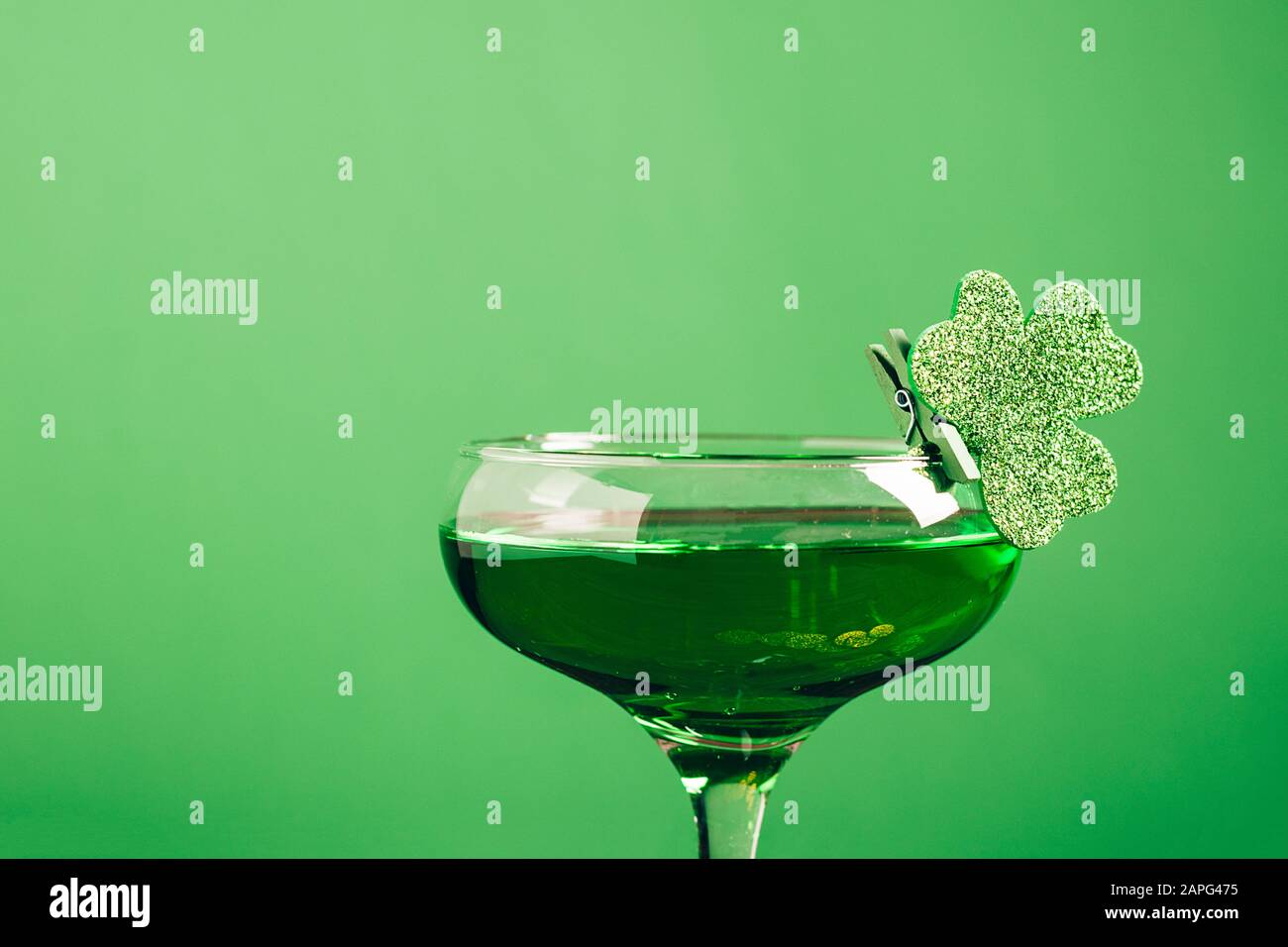 Traditional drink green clover beer in an elegant glass with a clover ...