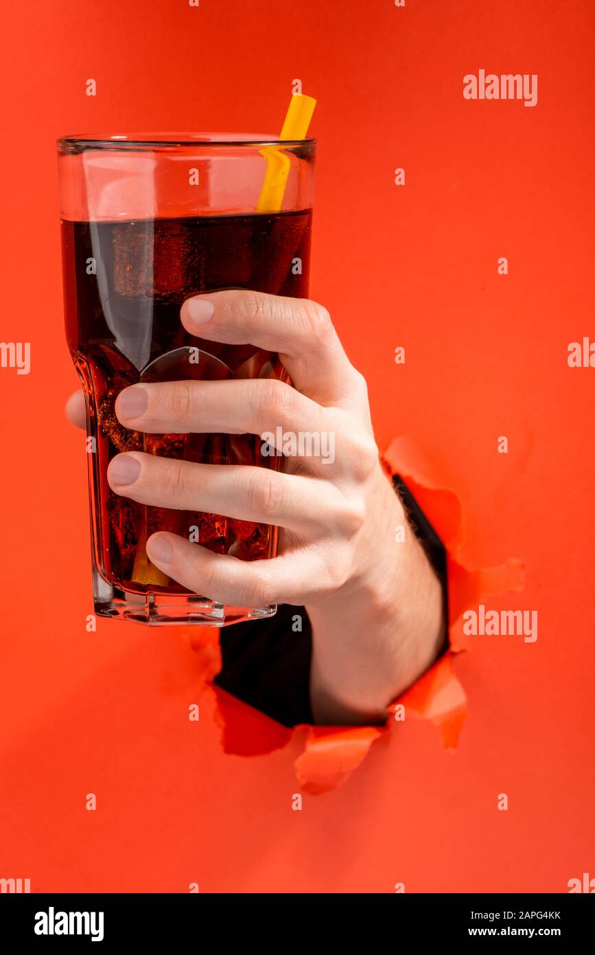Hand giving a glass of cola with a straw Stock Photo - Alamy