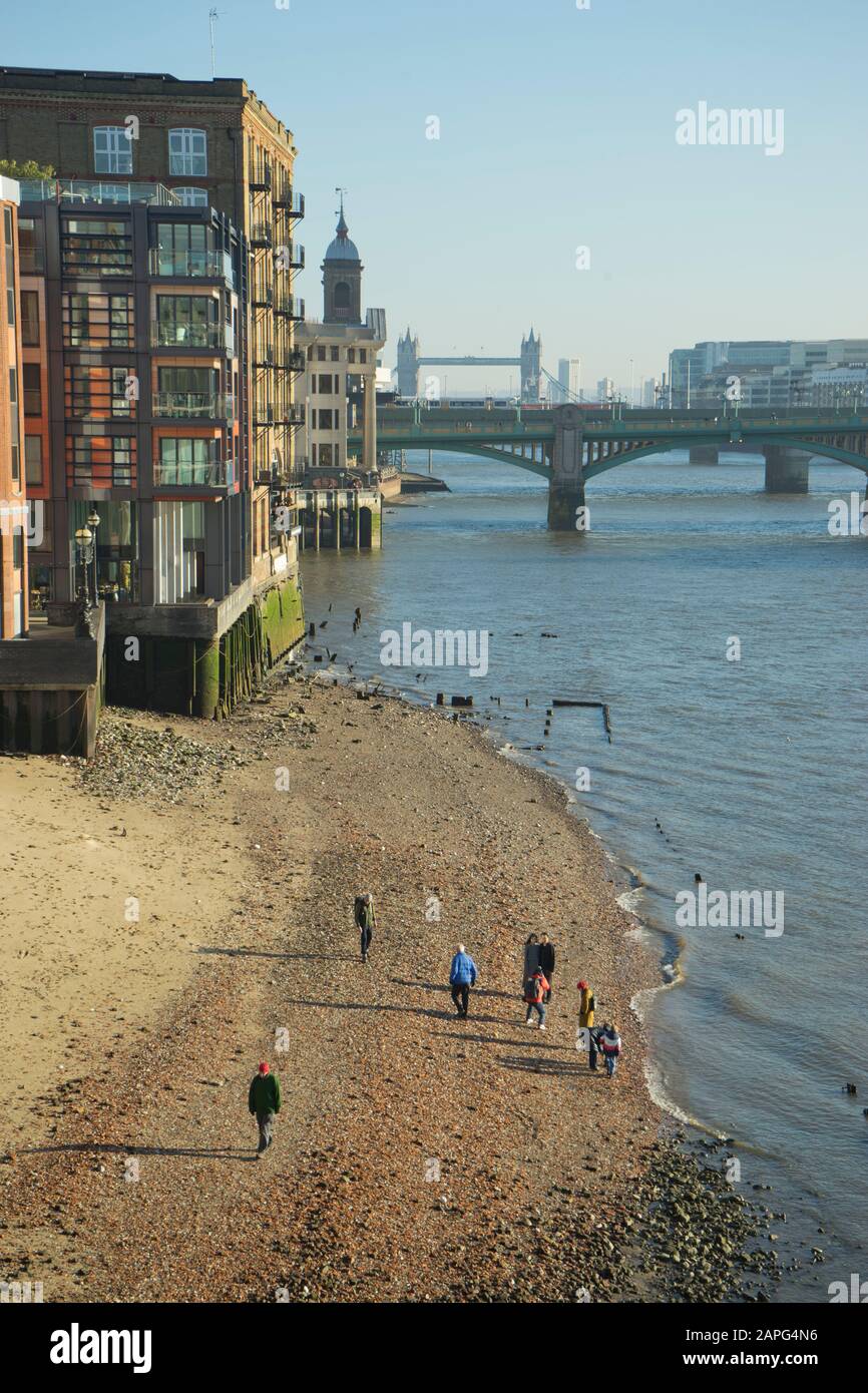 People walking along the pedestrian path by River Thames at low tide in ...
