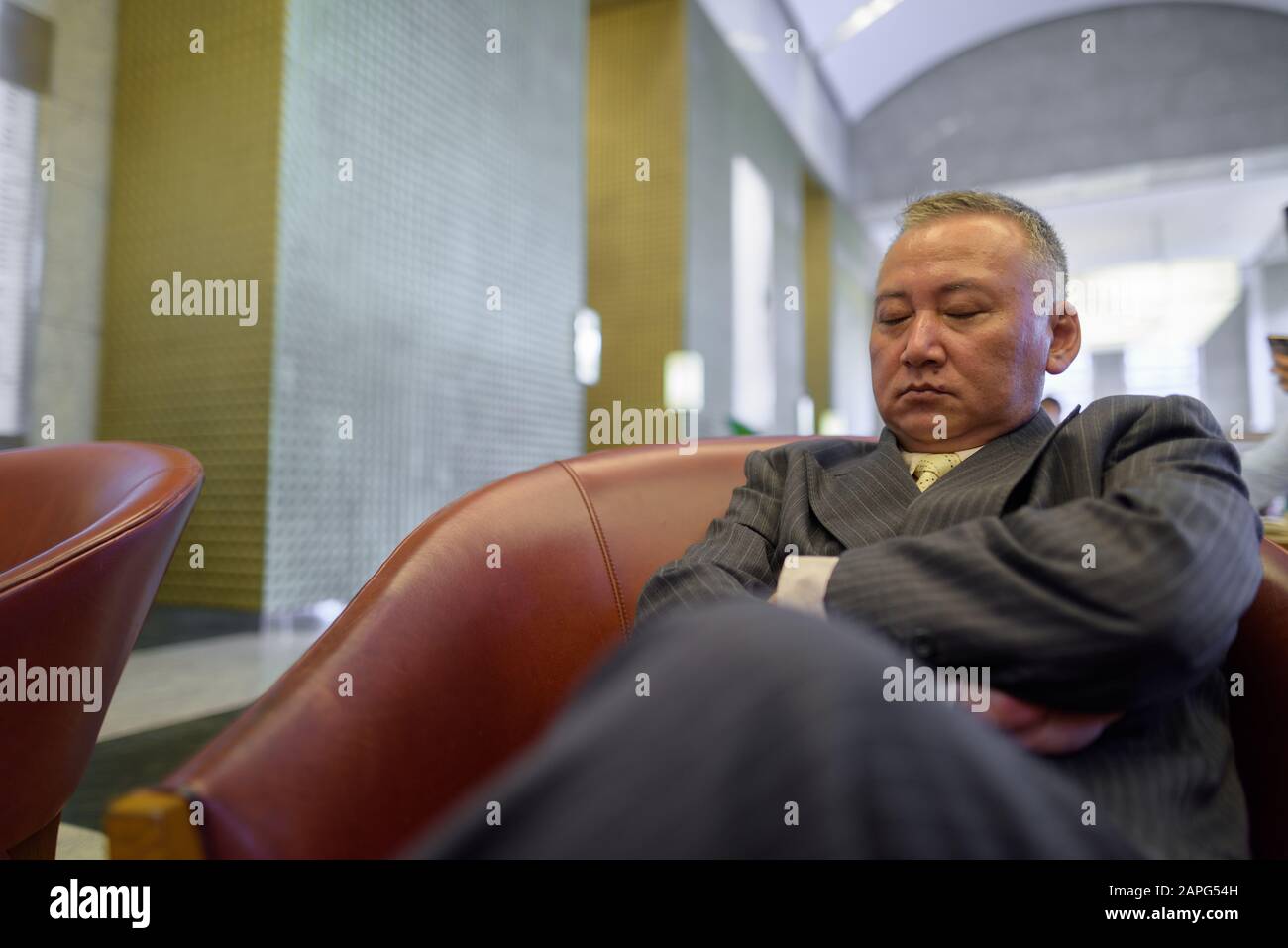 Portrait of mature Japanese businessman relaxing inside the coffee shop ...