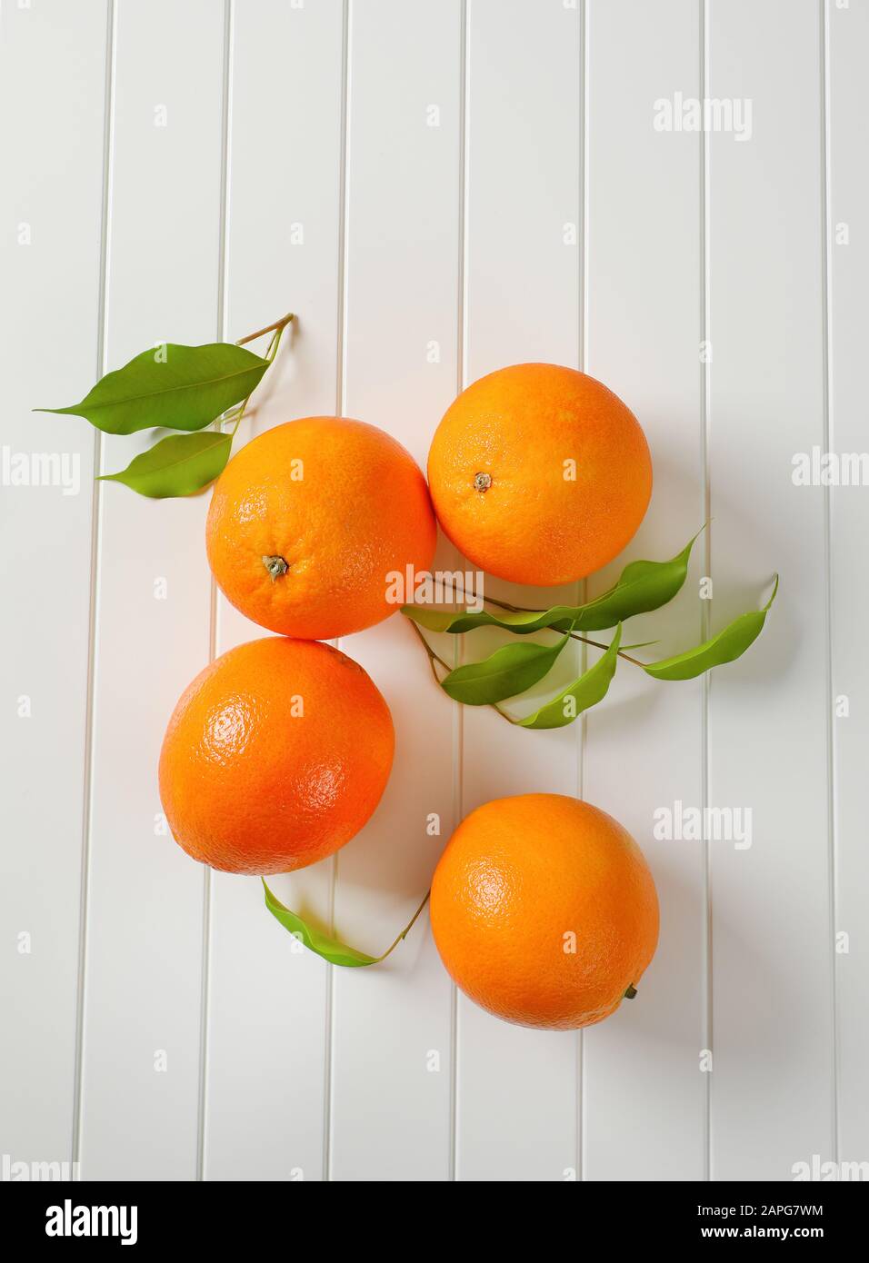 Four whole ripe oranges and leaves Stock Photo - Alamy