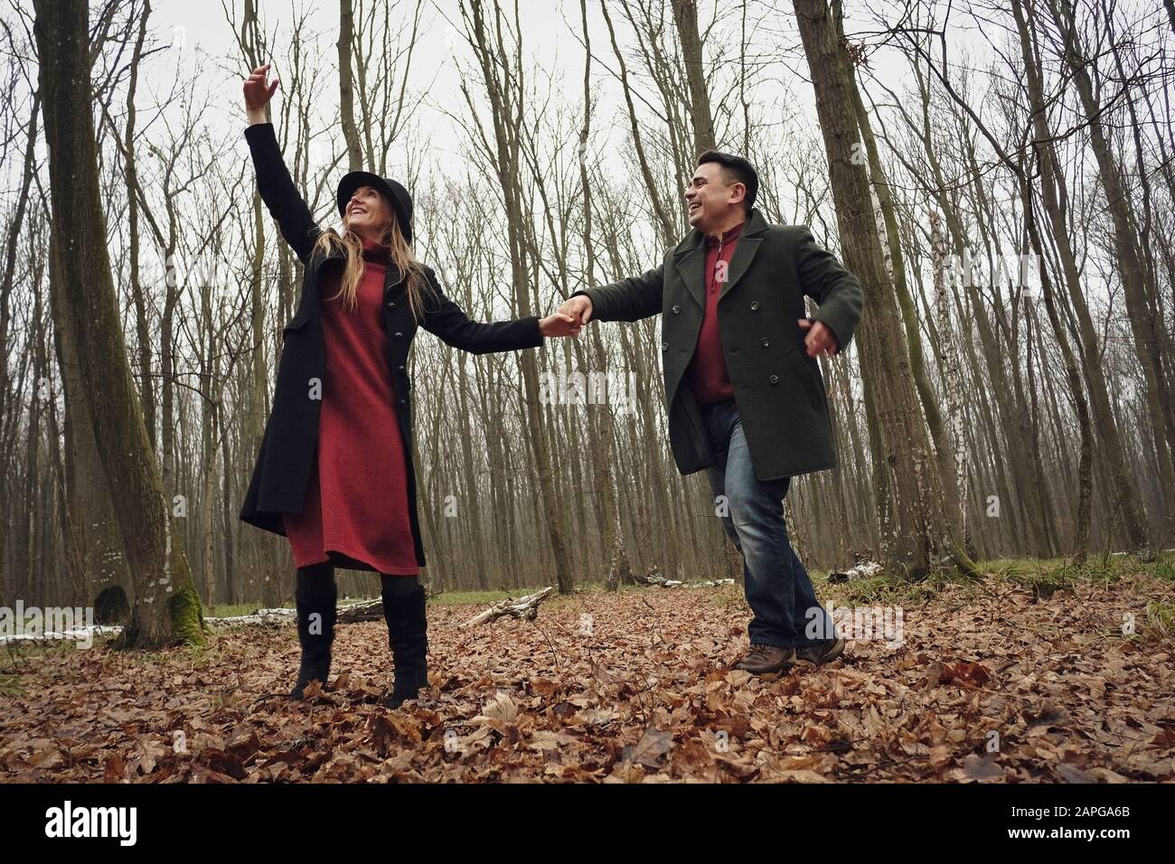 Happy couple enjoying a romantic walk in a forest Stock Photo - Alamy