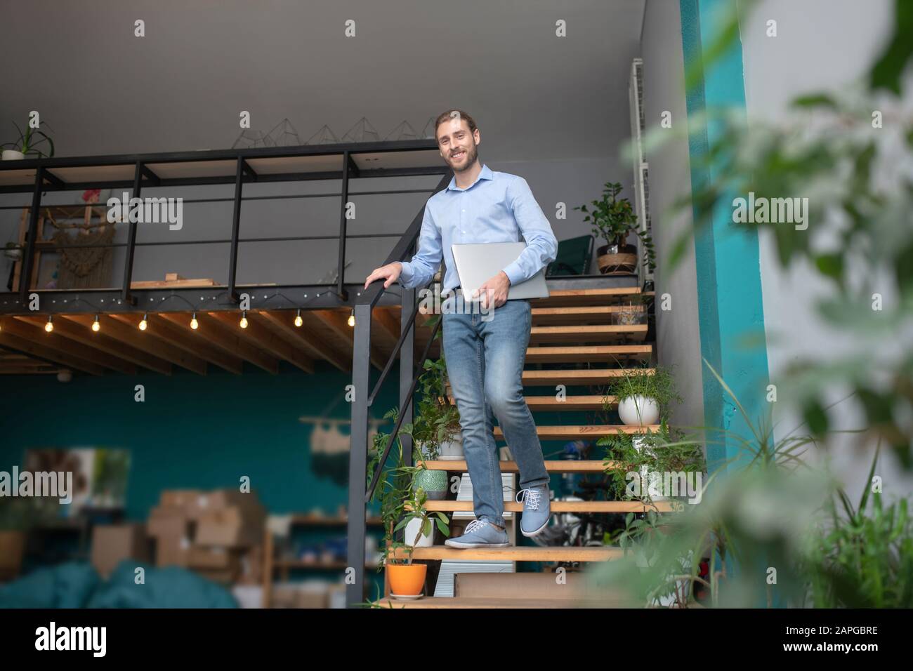 Man standing on stairs holding his computer Stock Photo - Alamy