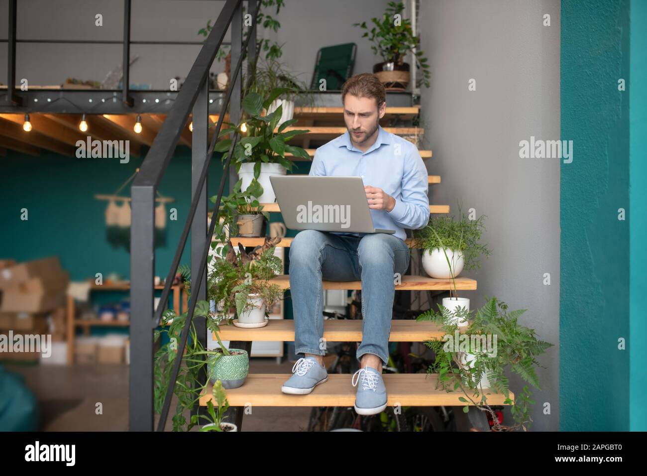 Man using a computer while sitting on stairs Stock Photo - Alamy