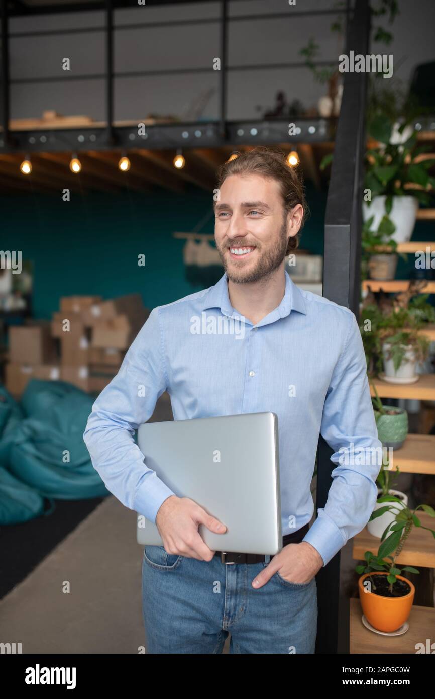 Smiling handsome man confidently holding his computer Stock Photo - Alamy