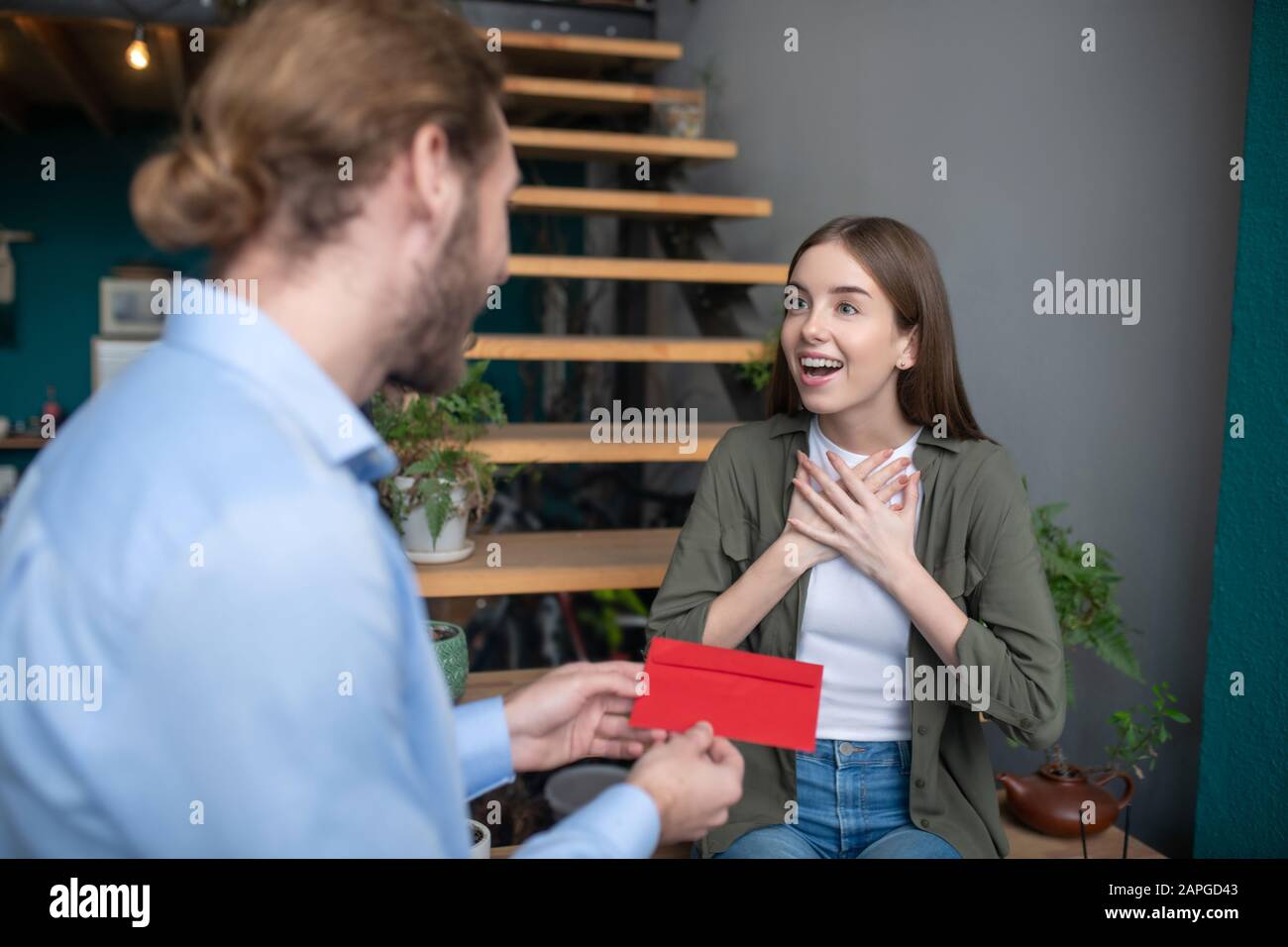 Man giving a red envelope to the admired woman Stock Photo - Alamy