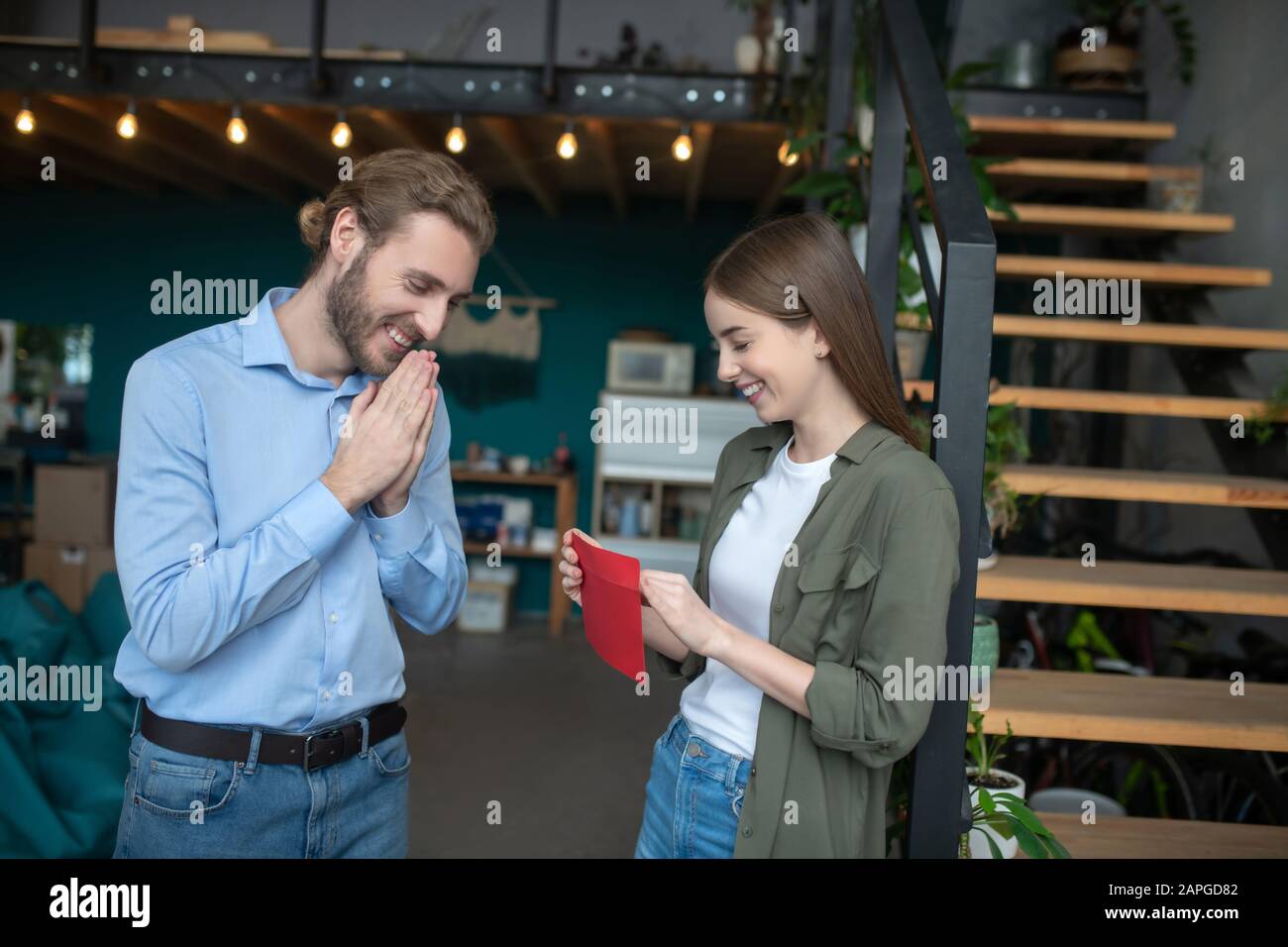 Smiling woman and man opening an envelope Stock Photo - Alamy