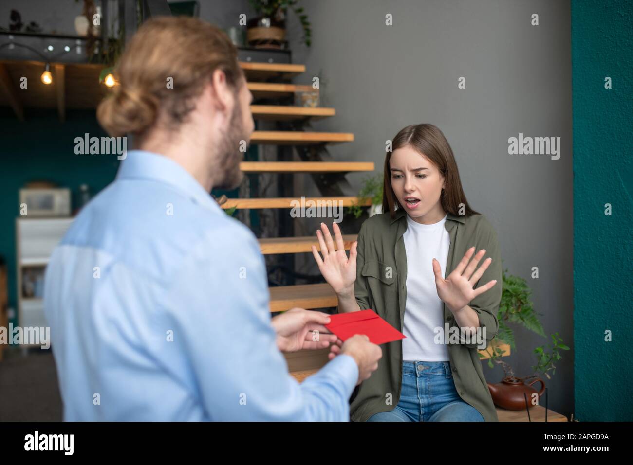 Man giving an envelope to the worried woman Stock Photo - Alamy