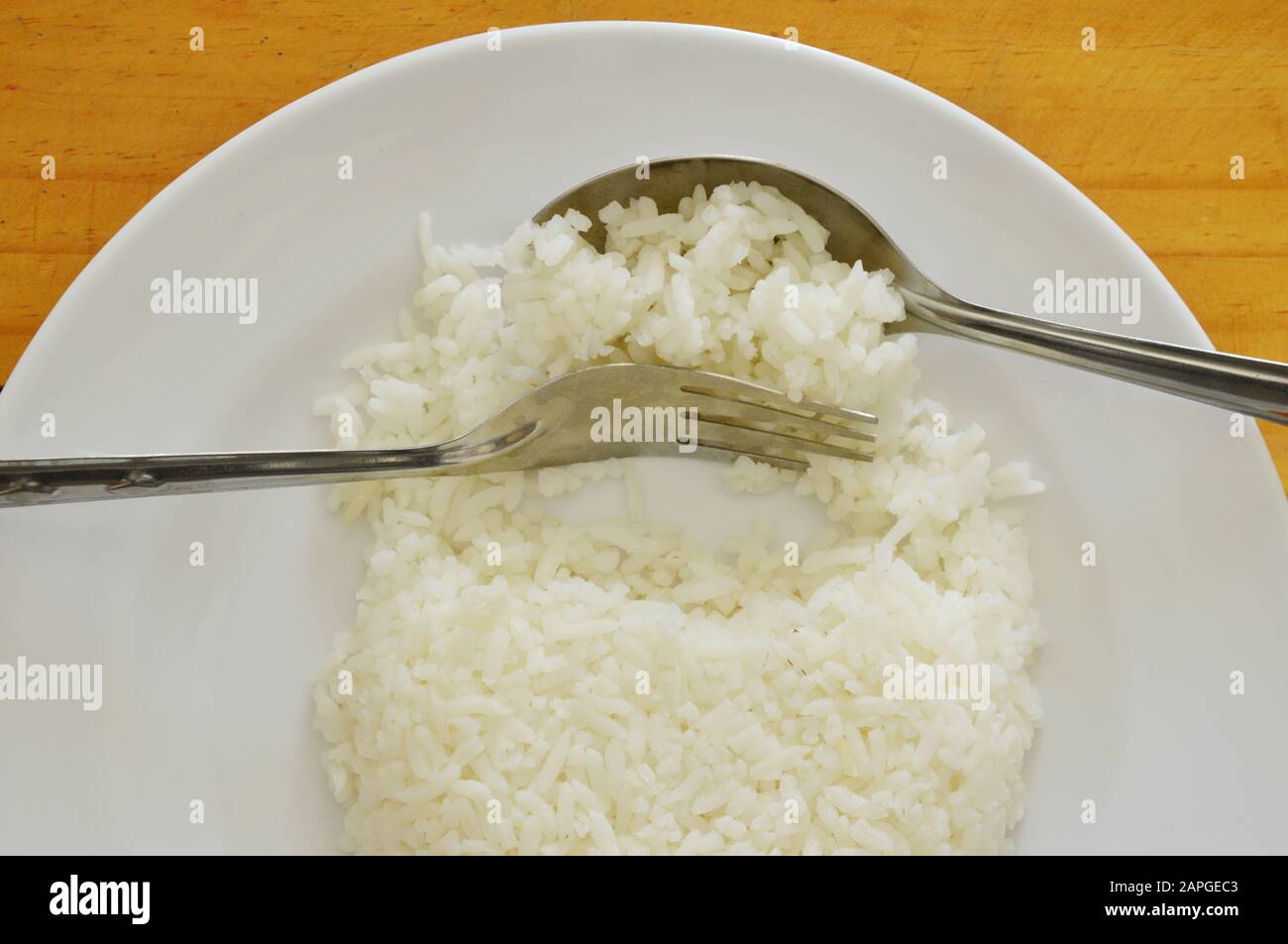 rice scooping by spoon and fork from plate for eating Stock Photo - Alamy