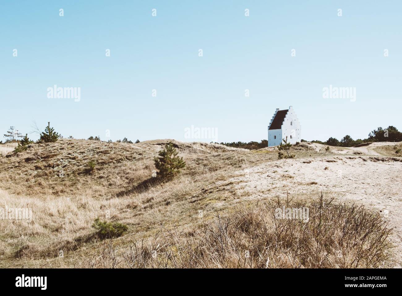 Wide angle shot of a white house on a dry landscape under a blue sky ...