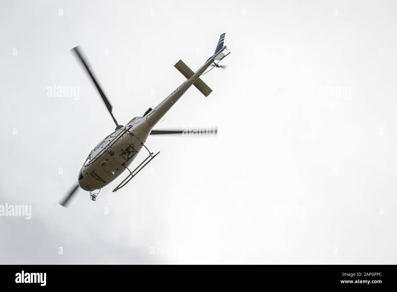 Shot of a helicopter from below against a white sky Stock Photo - Alamy