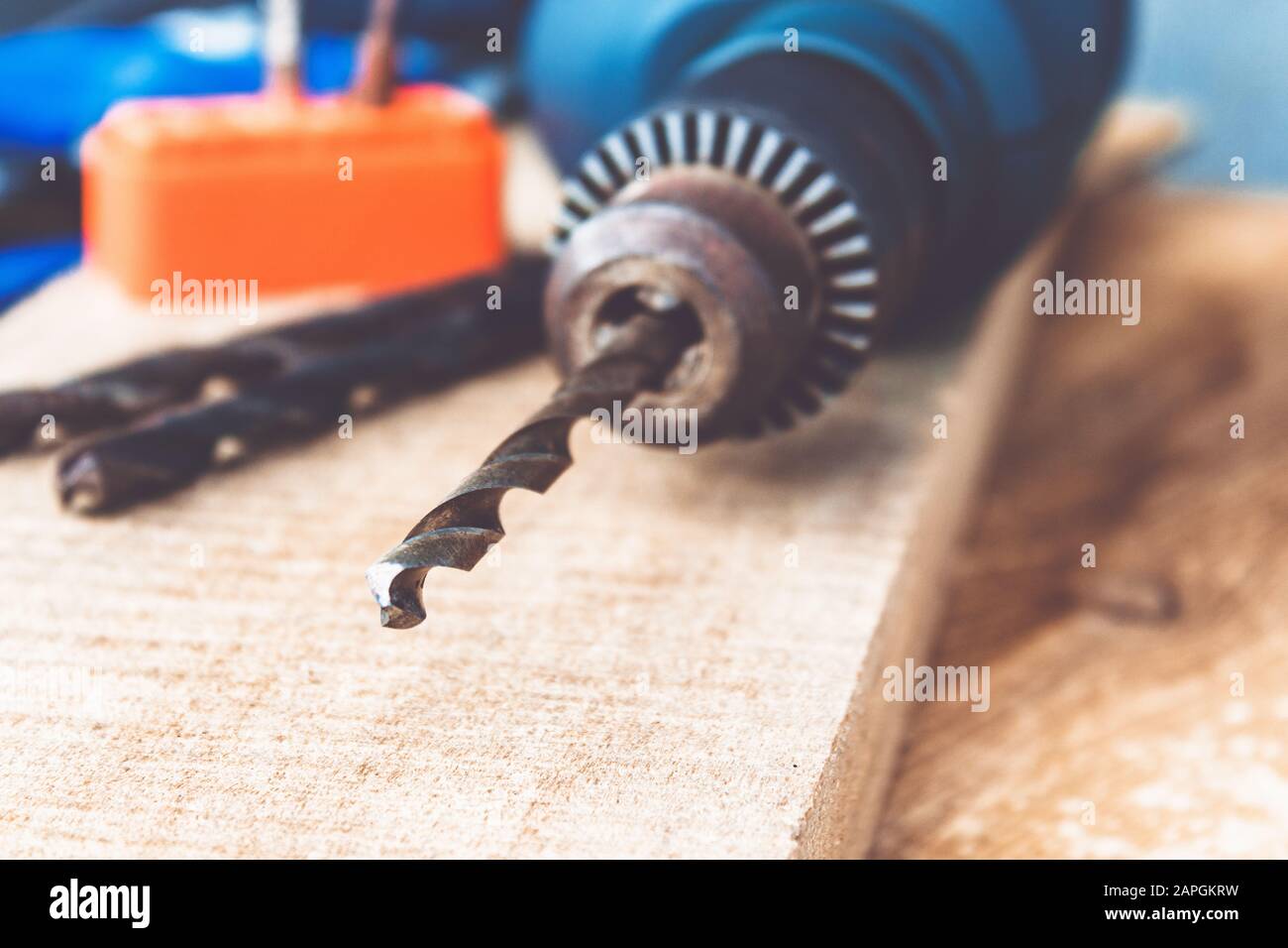 Drills in a power drill on a wooden background. The concept of tools ...