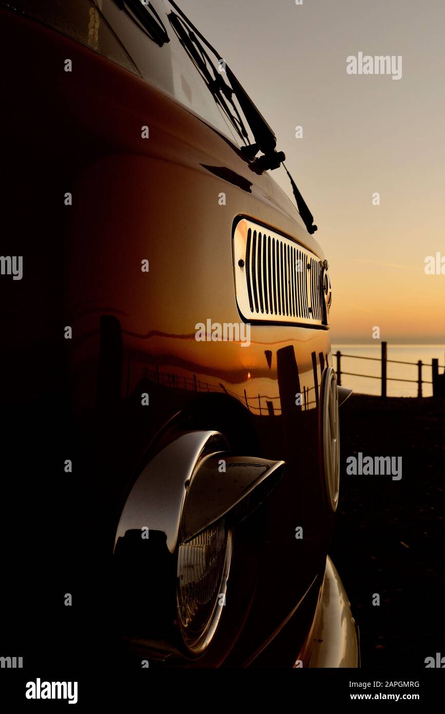 A parked VW Volkswagen campervan at sunrise / sunset. Hastings, East ...