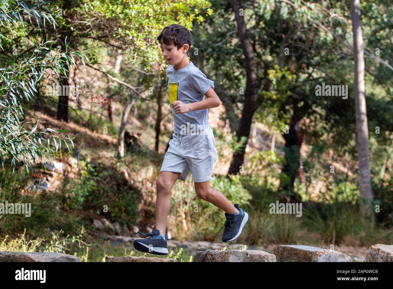 Cute boy in sport clothing running Stock Photo - Alamy