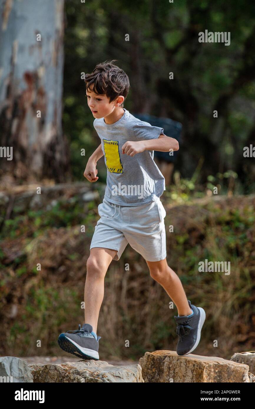 Cute boy in sport clothing running Stock Photo - Alamy