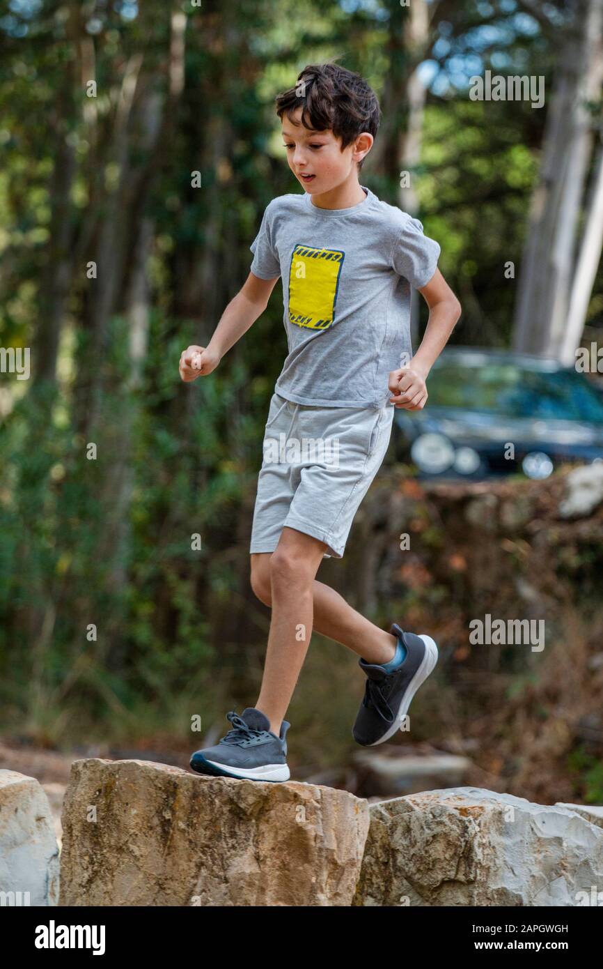 Cute boy in sport clothing running Stock Photo - Alamy