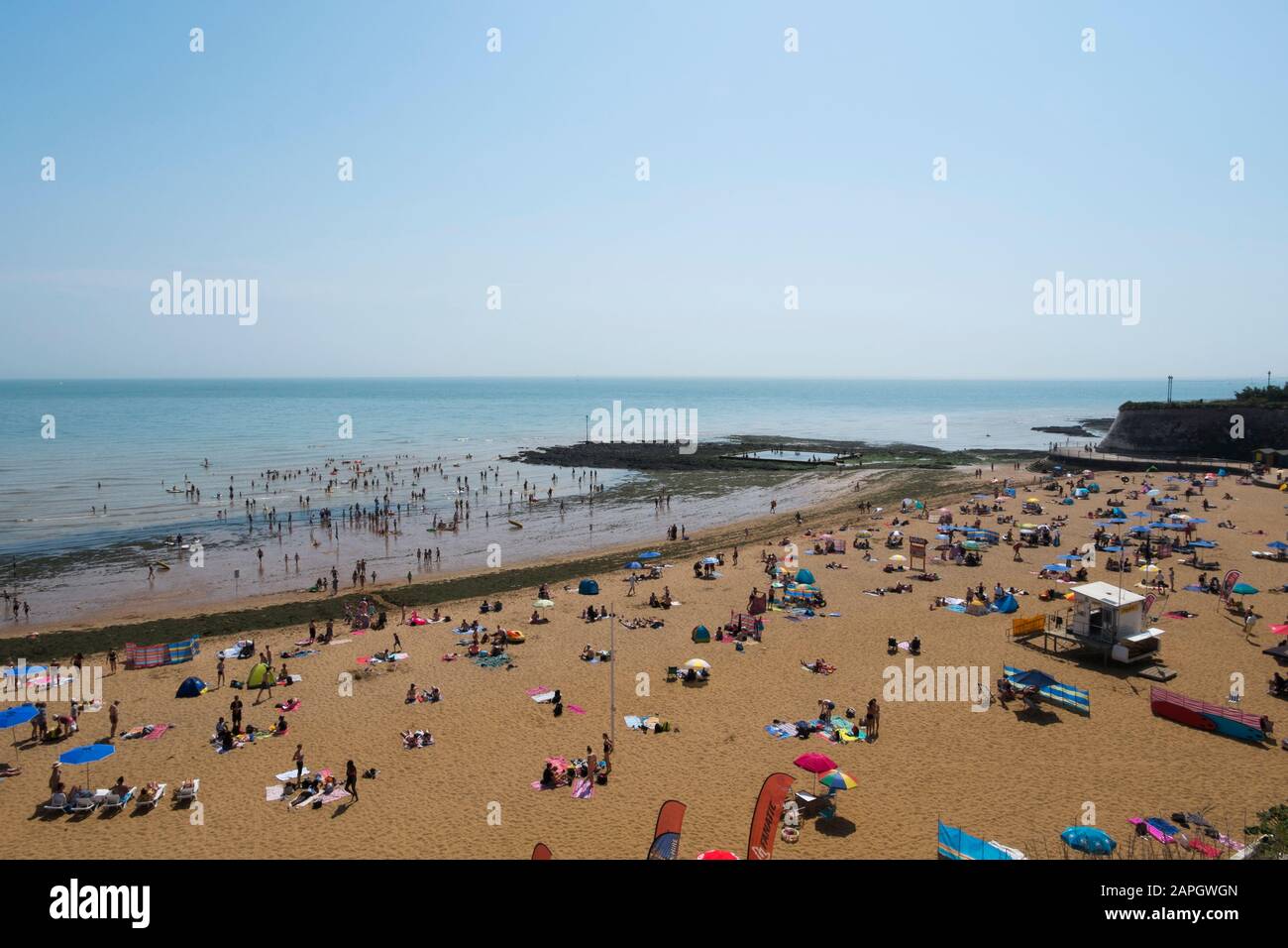 People sunbathing and kids playing on the beach at Viking Bay ...