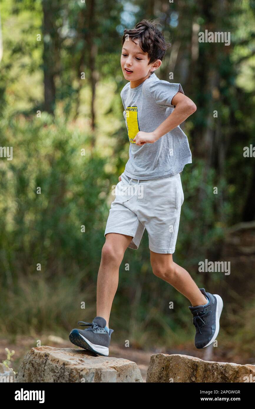 Cute boy in sport clothing running Stock Photo - Alamy