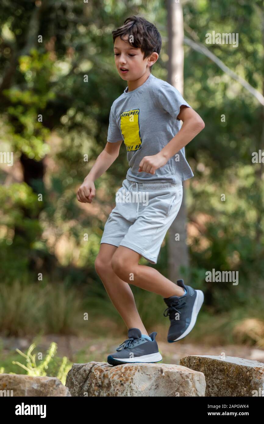 Cute boy in sport clothing running Stock Photo - Alamy