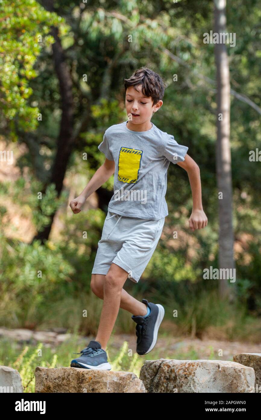 Cute boy in sport clothing running Stock Photo - Alamy