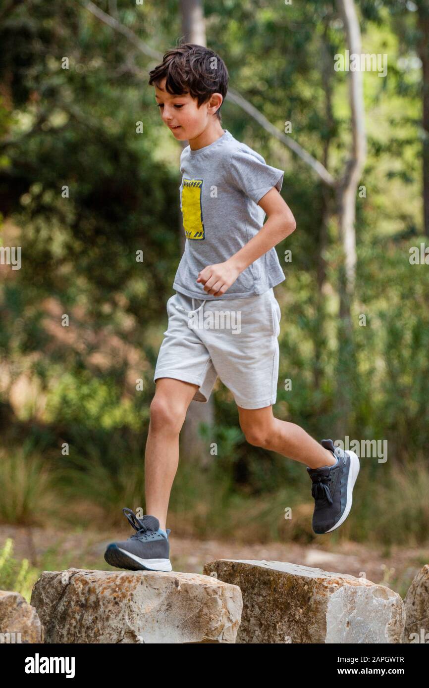 Cute boy in sport clothing running Stock Photo - Alamy