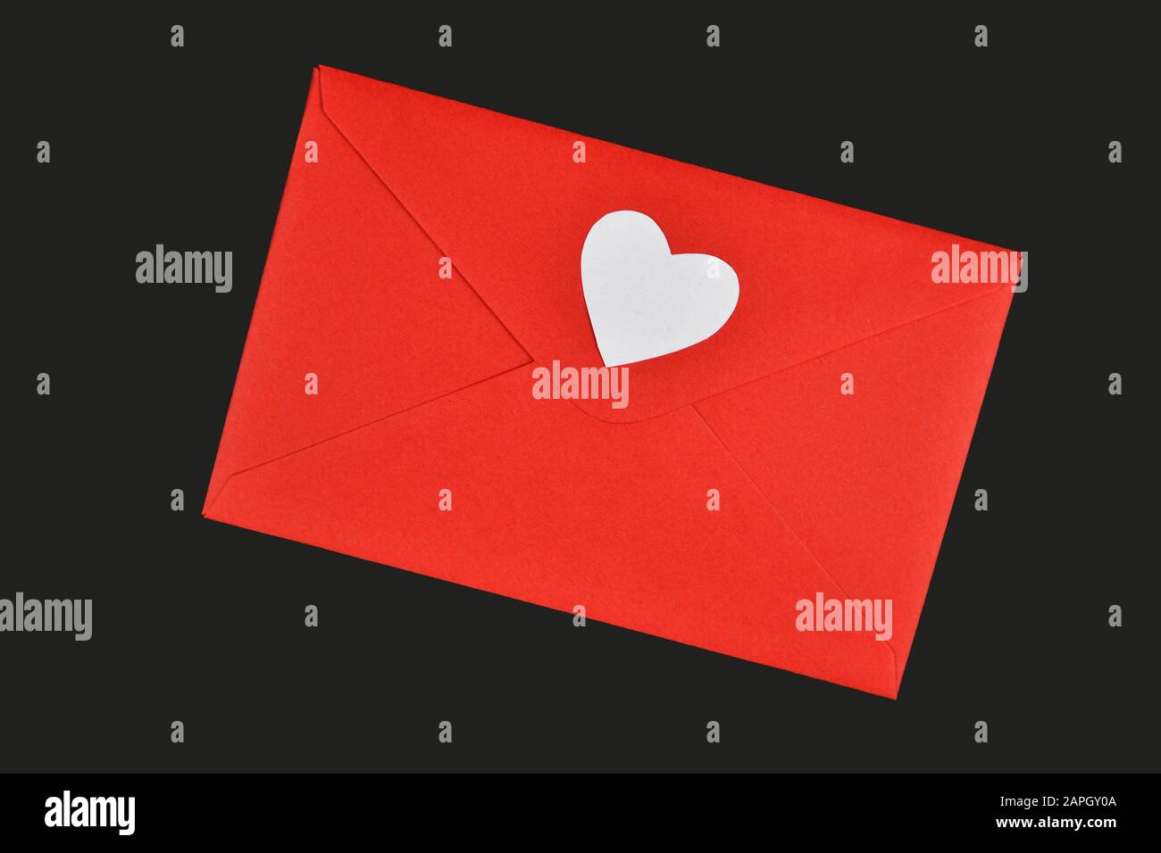 Back side of red love letter with white heart on black background Stock ...