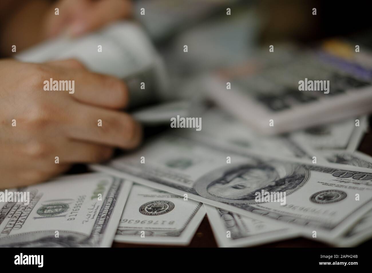 Businessmen women counting money on a stack of 100 US dollars banknotes ...