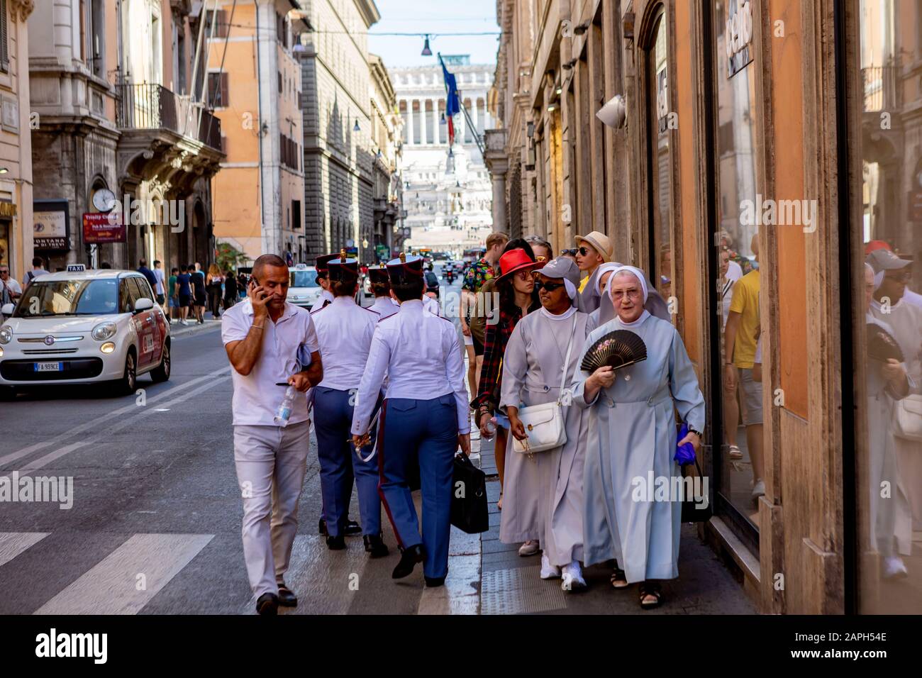 A group of nuns passing a group of female army cadets on a street in ...